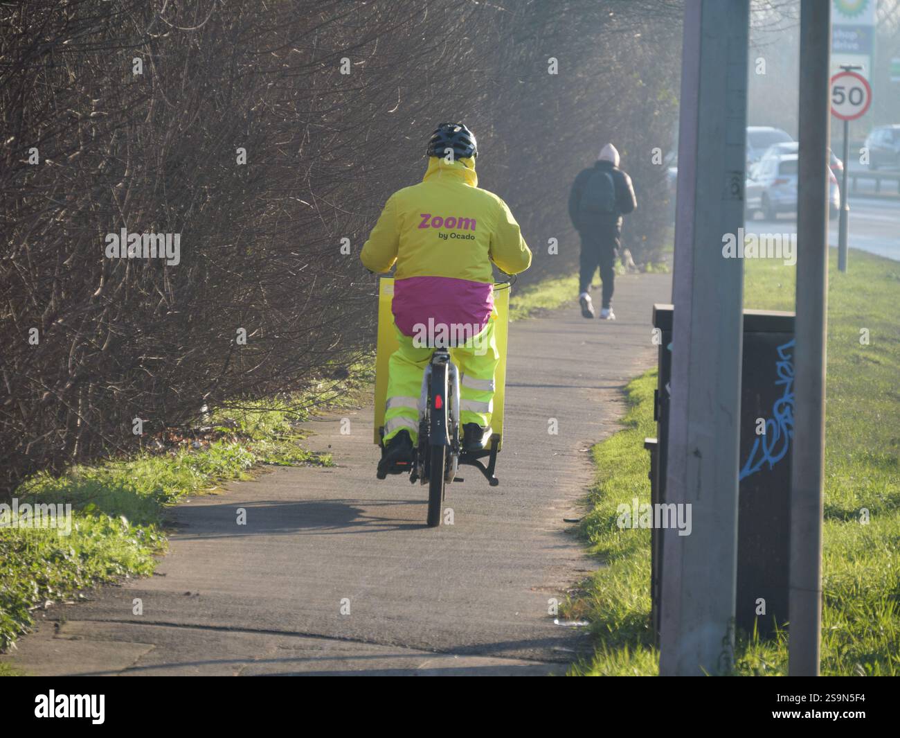 Zoom by Ocado delivery e-bike cyclist riding on pavement near North ...
