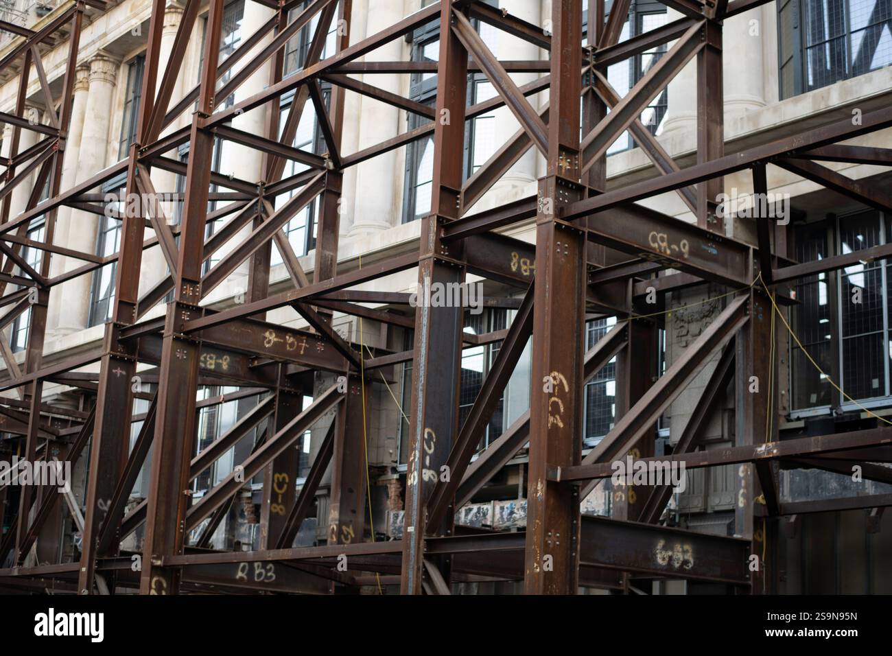 Steel beam framework surrounding a concrete building Stock Photo - Alamy