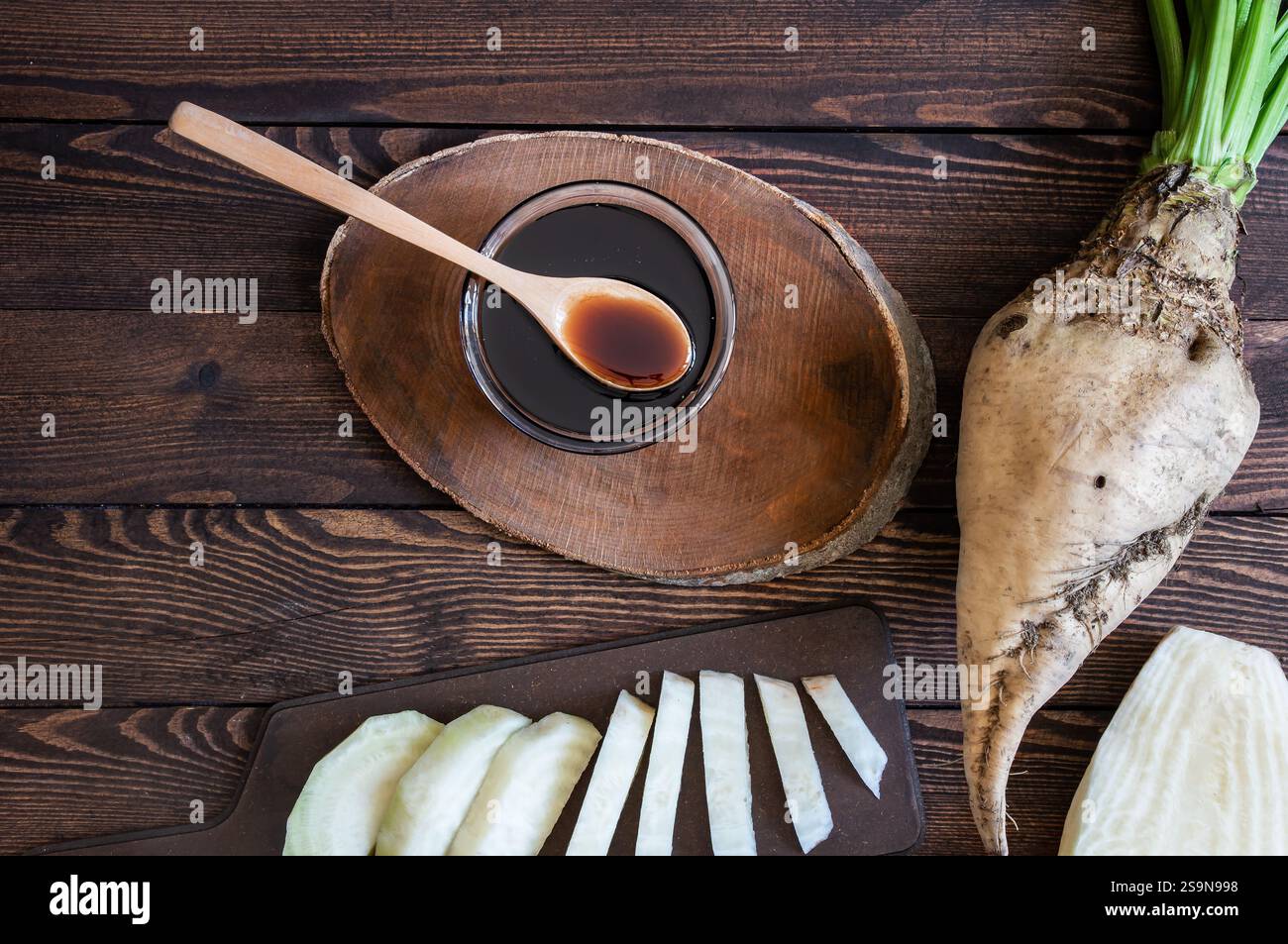 Sugar beet molasses in glass bowl with fresh sugar beetroot plant ...