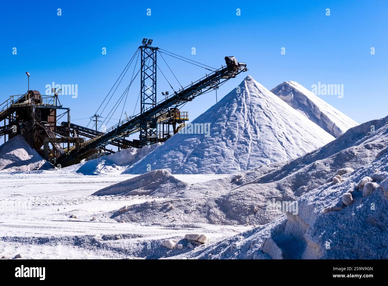 Large piles of white salt and conveyor belts in the Sant Antioco salt ...