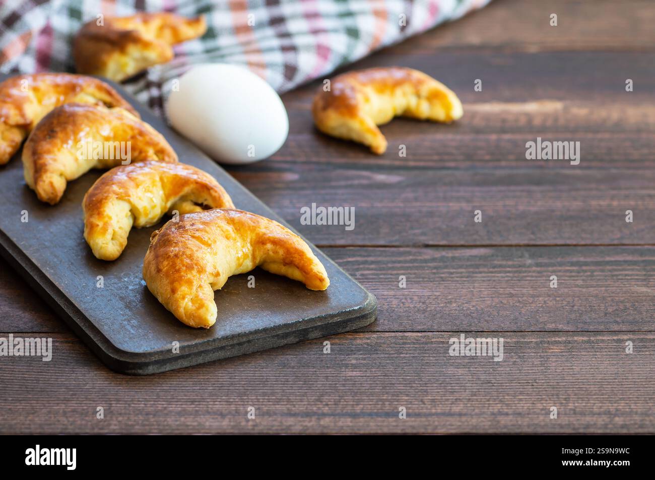Homemade salty moon bun on wooden table, croissant, cookies potato and ...