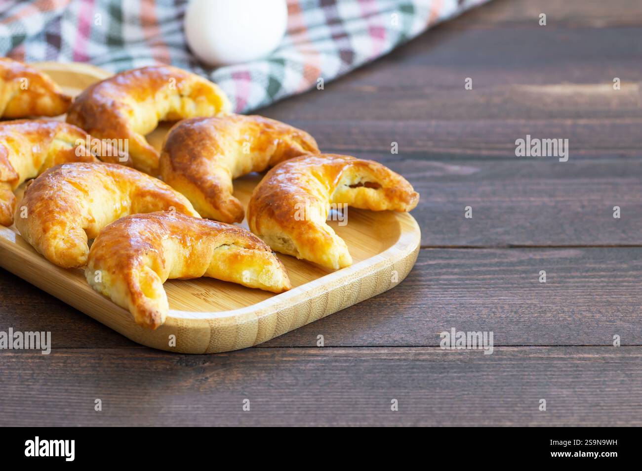 Homemade salty moon bun on wooden table, croissant, cookies potato and ...