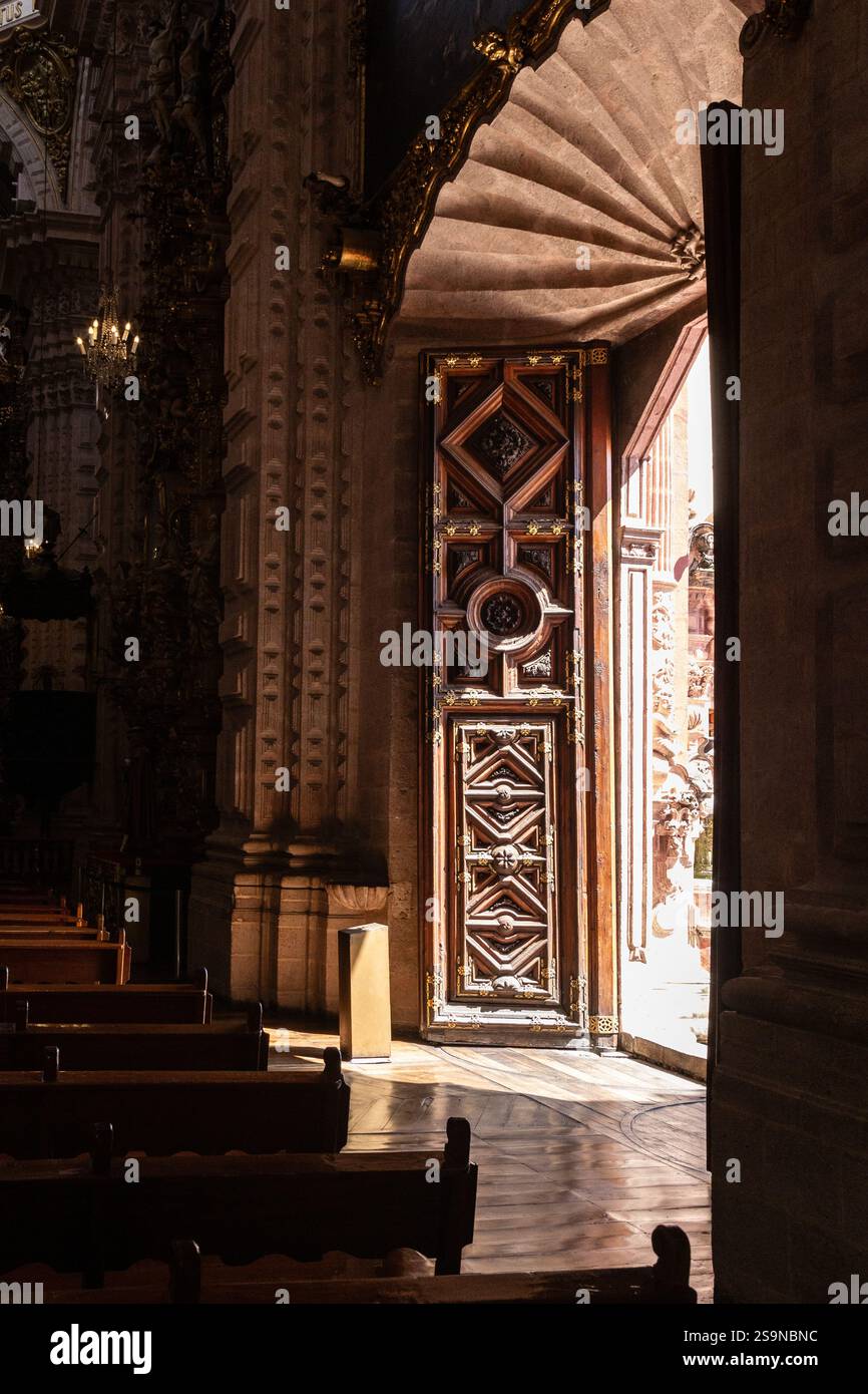Golden light hitting carved wooden door in barroque church of Mexico ...