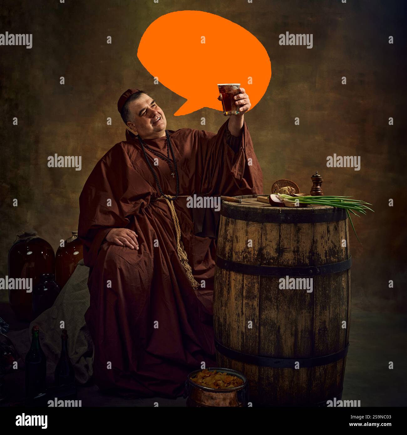 Man, medieval monk lifting glass of beer, pint of ale against dark ...