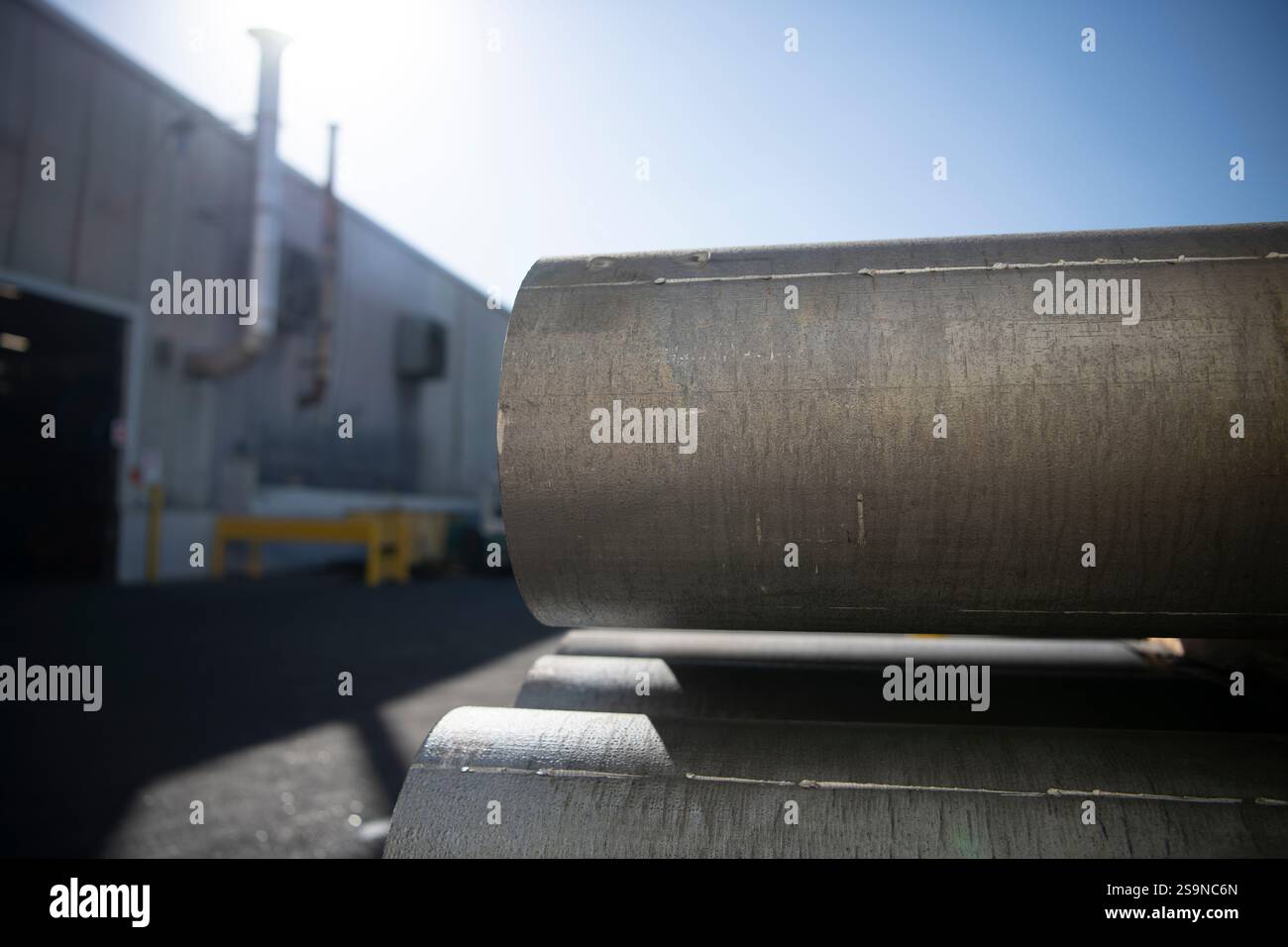 End of a raw aluminum billet sitting in an outdoor processing yard ...