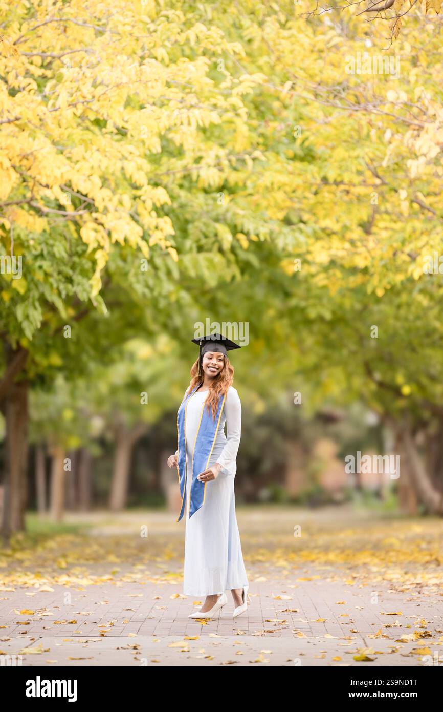 Graduation woman walking in the fall with her graduation cap Stock ...