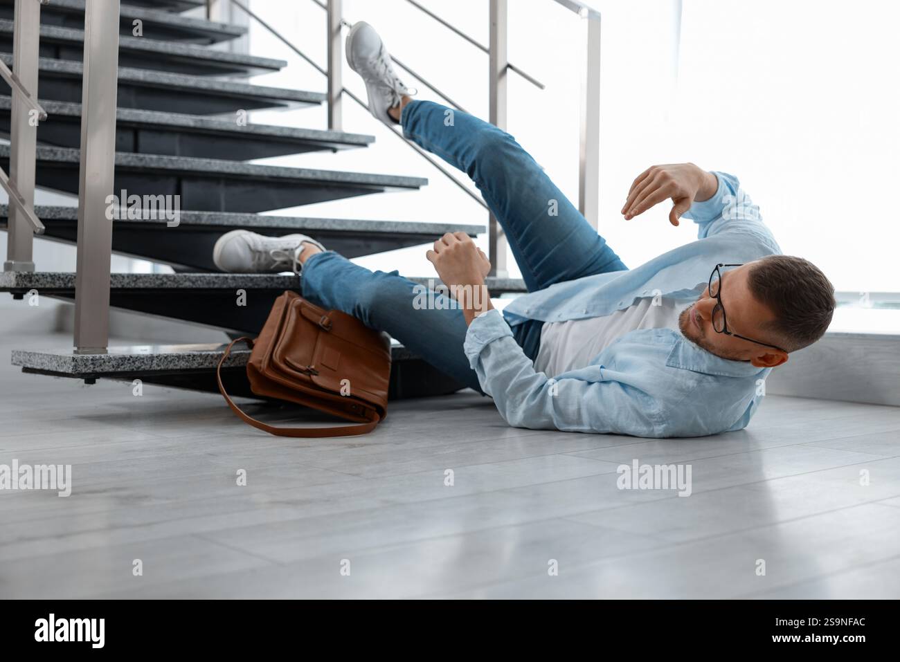 Injured man on floor in building after fall from stairs. Dangerous ...