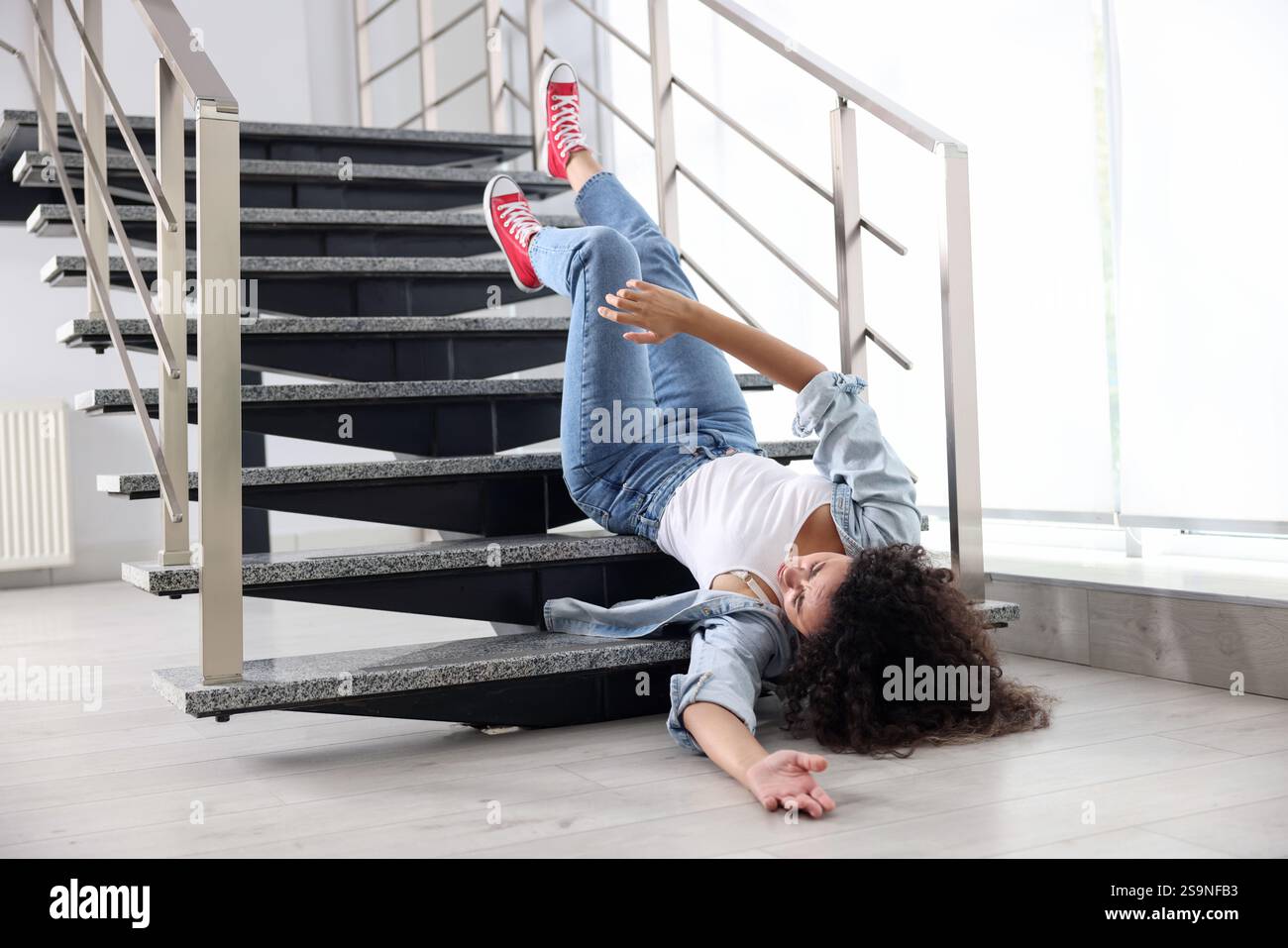 Injured woman on stairs in building after fall. Dangerous accident ...