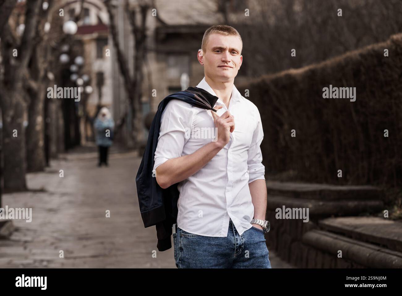 Confident Young Man in Urban Setting with Jacket Over Shoulder Stock ...