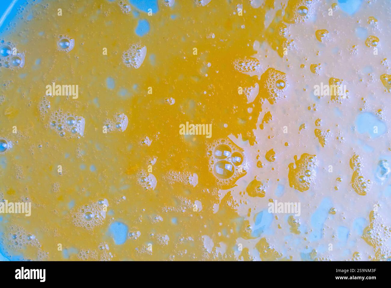 Background with egg yolk texture on a blue plate. Culinary background ...