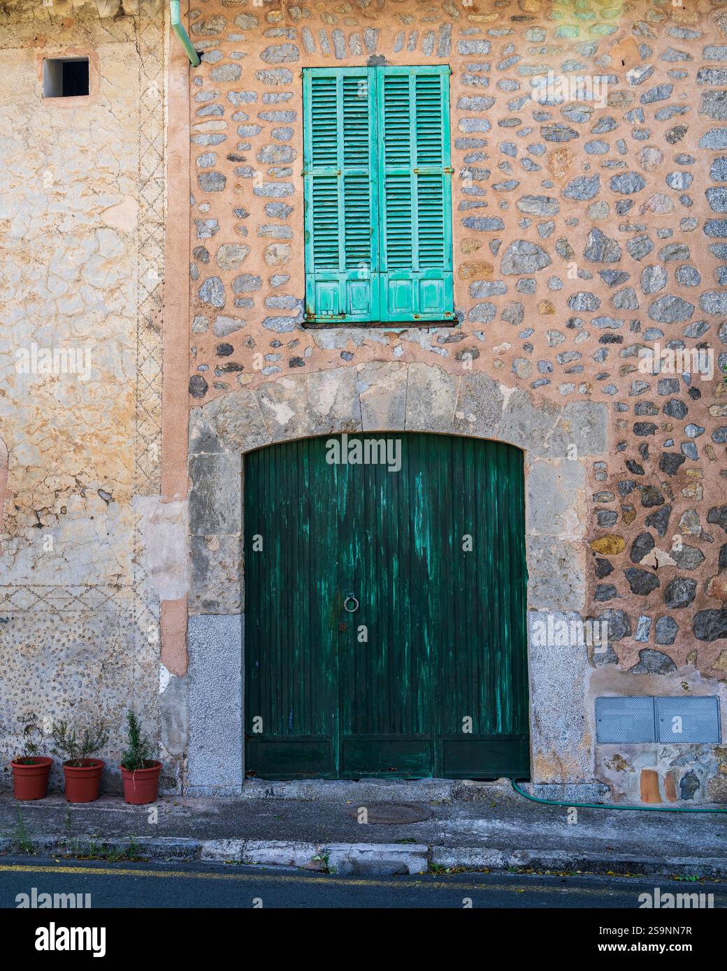 Traditional stone house in Mallorca with small window, an old green ...