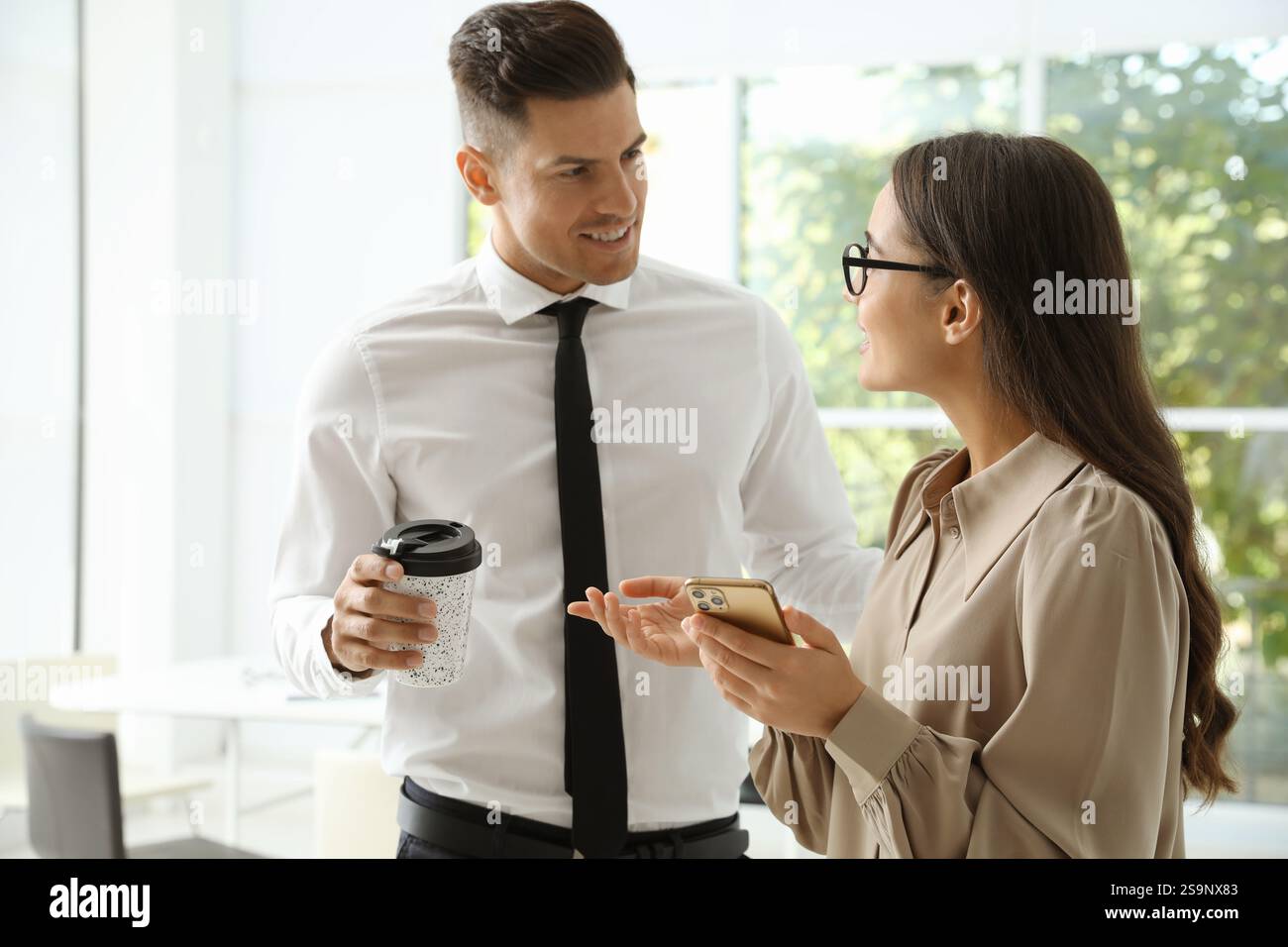 Office employees talking at workplace during break Stock Photo - Alamy