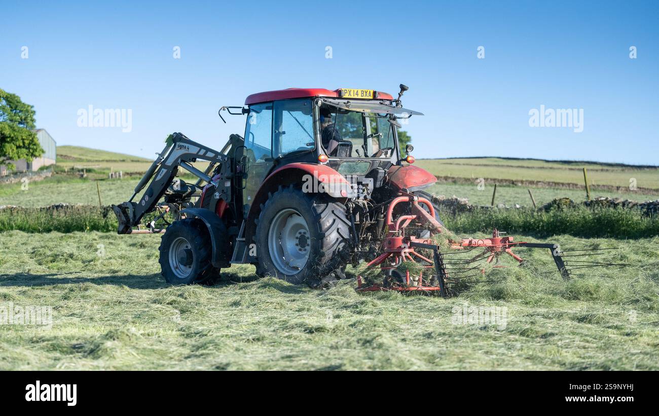 A Zetor tractor spreading grass out to make hay near tan hill Stock ...