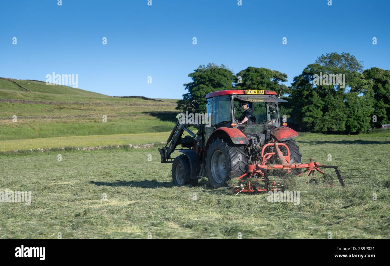 A Zetor tractor spreading grass out to make hay near tan hill Stock ...