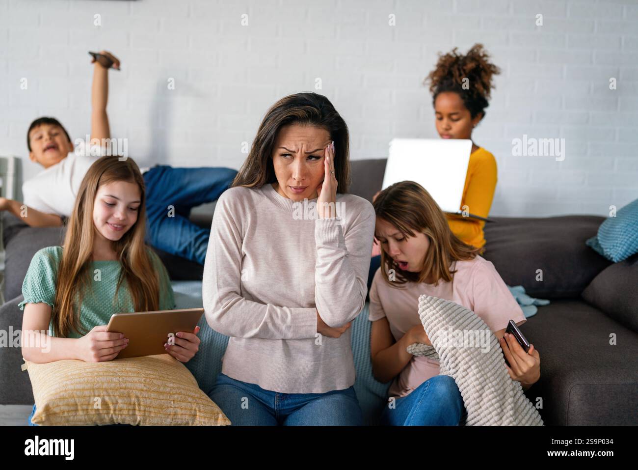 Sad woman with multiethnic children using digital gadgets.. Family and ...