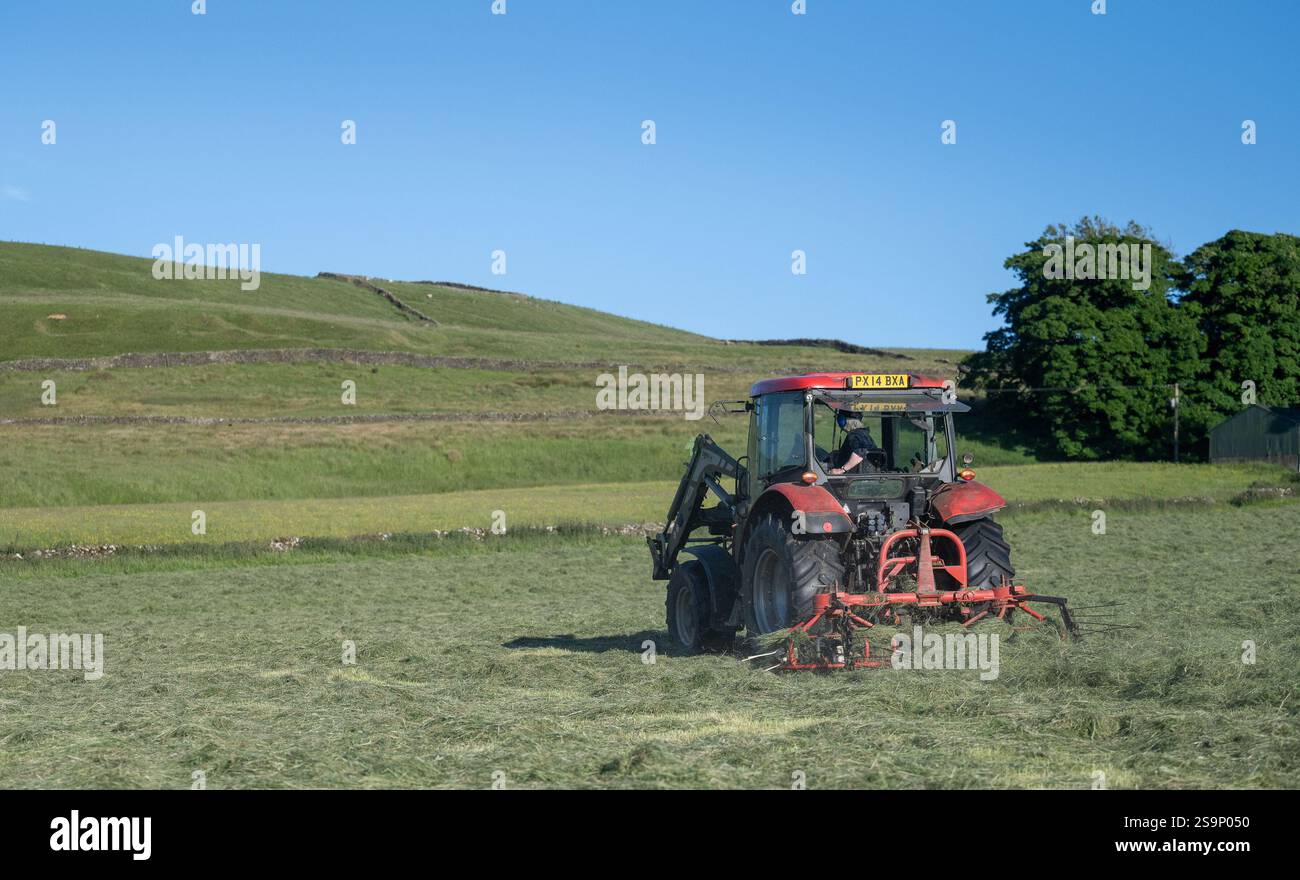 A Zetor tractor spreading grass out to make hay near tan hill Stock ...