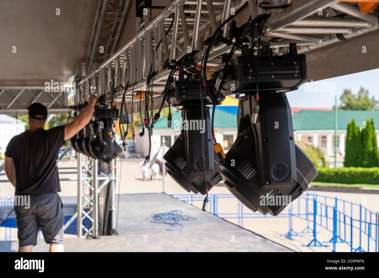 Installation of lighting equipment on a mobile concert stage. A worker ...