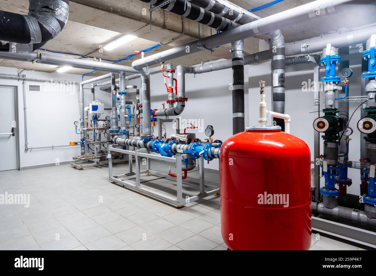 Equipment setup in a modern utility room featuring pipes, valves, and a ...