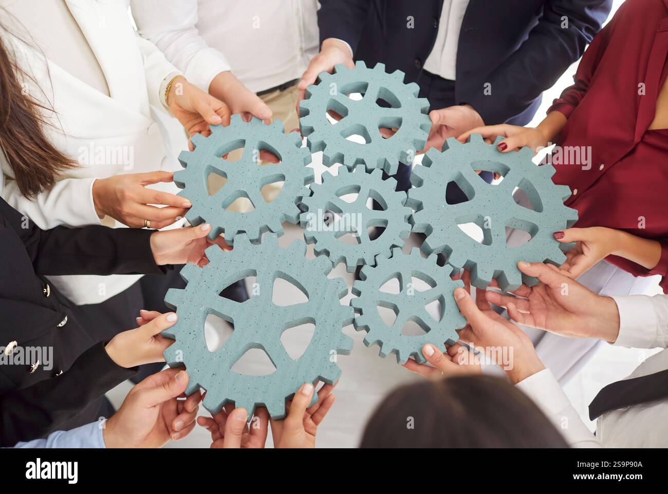 Team hands holding gear pieces, driven parts, wheels, join, connecting ...