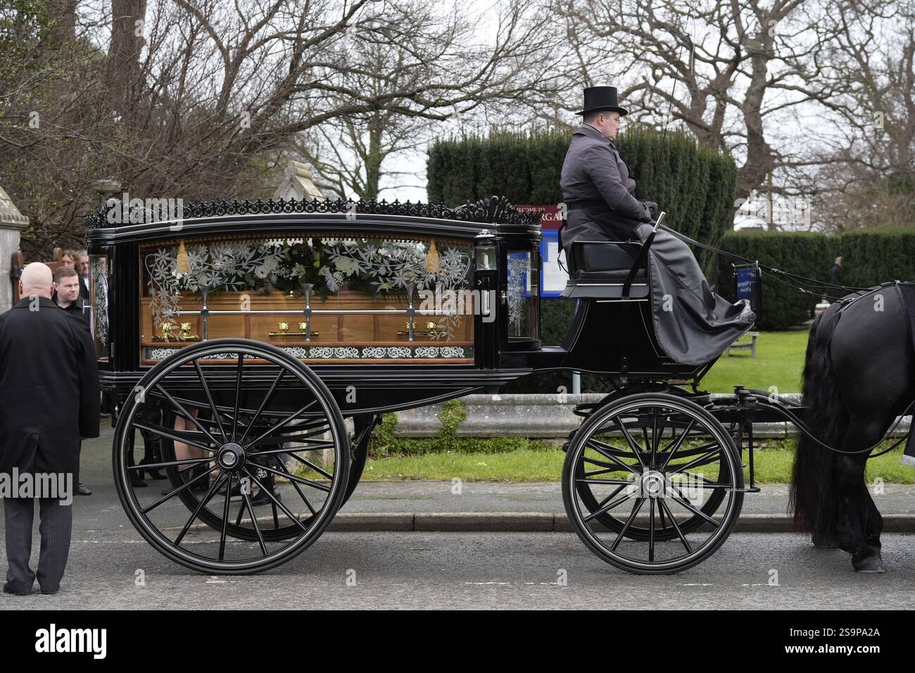 A horse-drawn carriage carrying the coffin of The Vivienne arrives at a ...