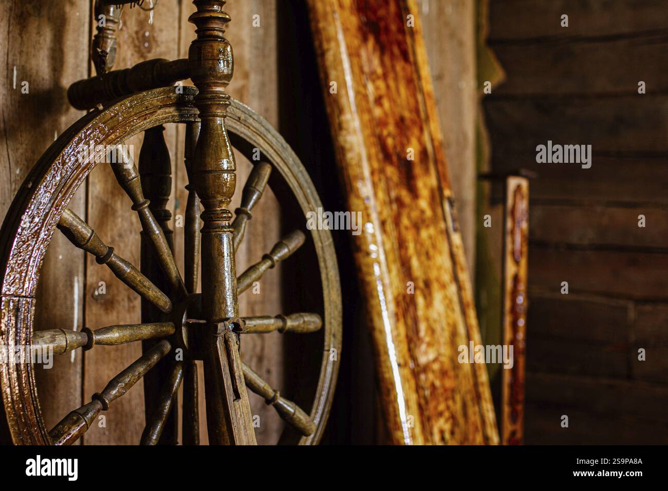 An old wooden wheel leaning against a rustic backdrop in a workshop ...