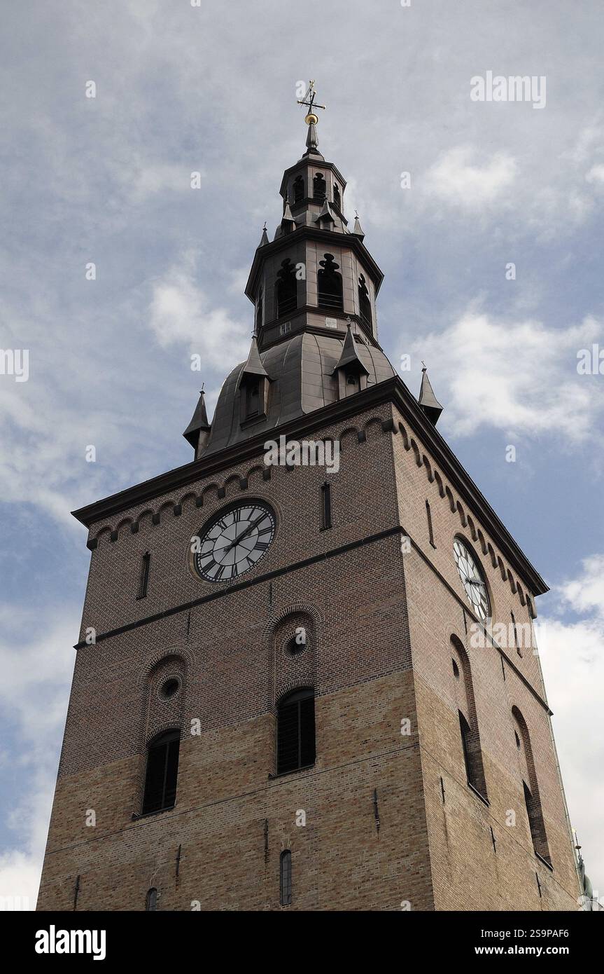 A tall church tower with a clock and gothic architecture under a blue ...
