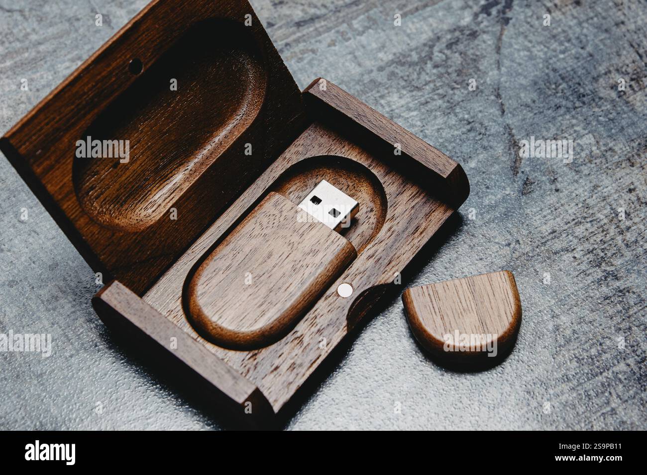 A USB stick inside a dark wooden case with an open lid on a textured ...
