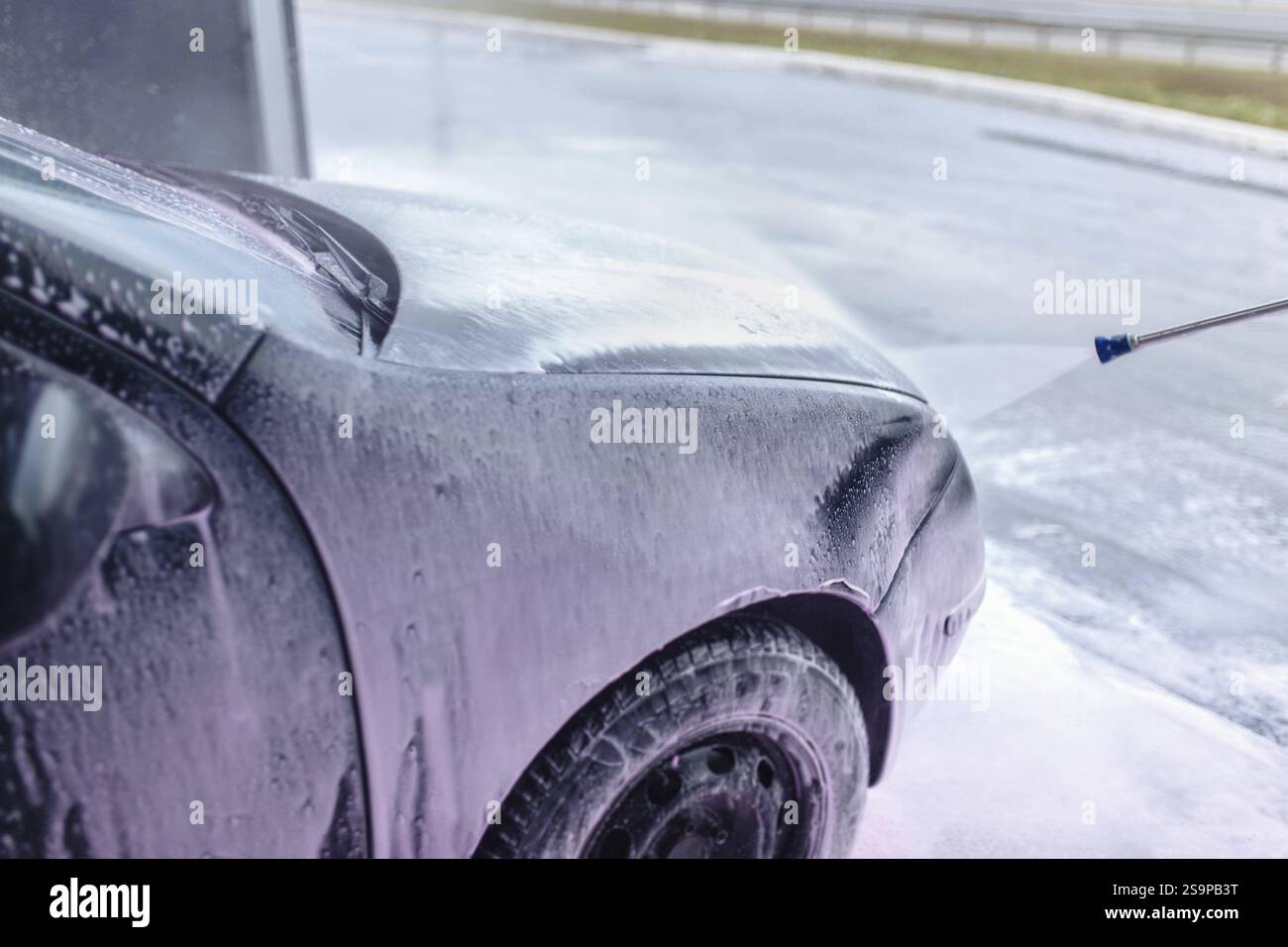 Car being washed with foam and water at a car wash station Stock Photo ...