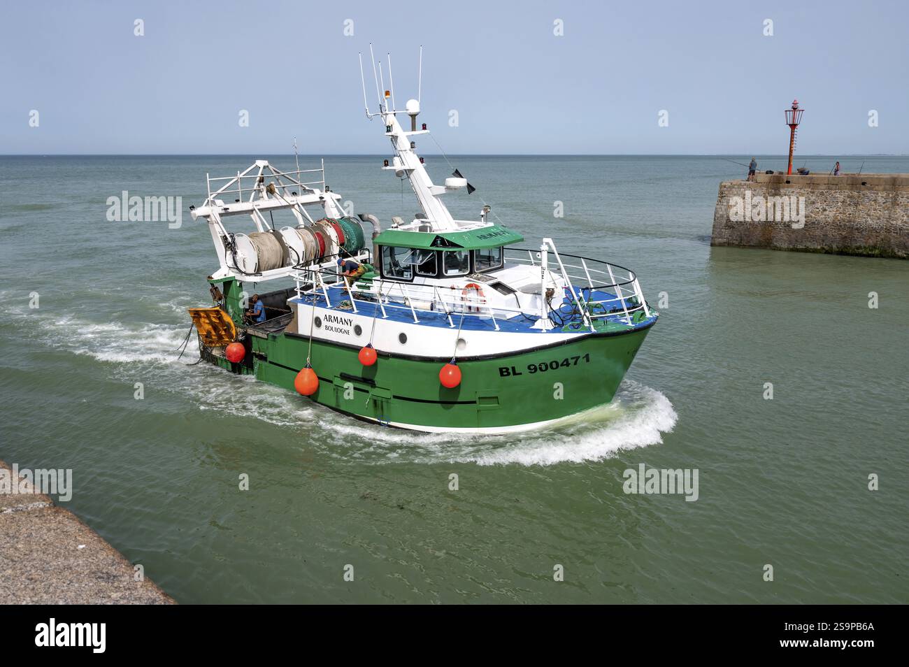 Green and white fishing trawler returning to the port of Le Treport ...