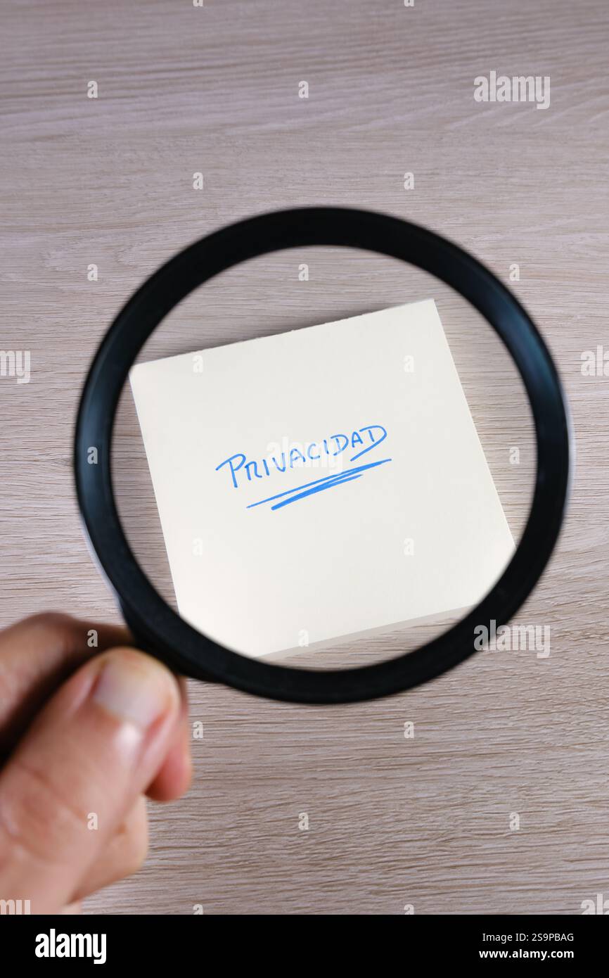 Magnifying glass focusing on the word privacy written on a sticky note ...