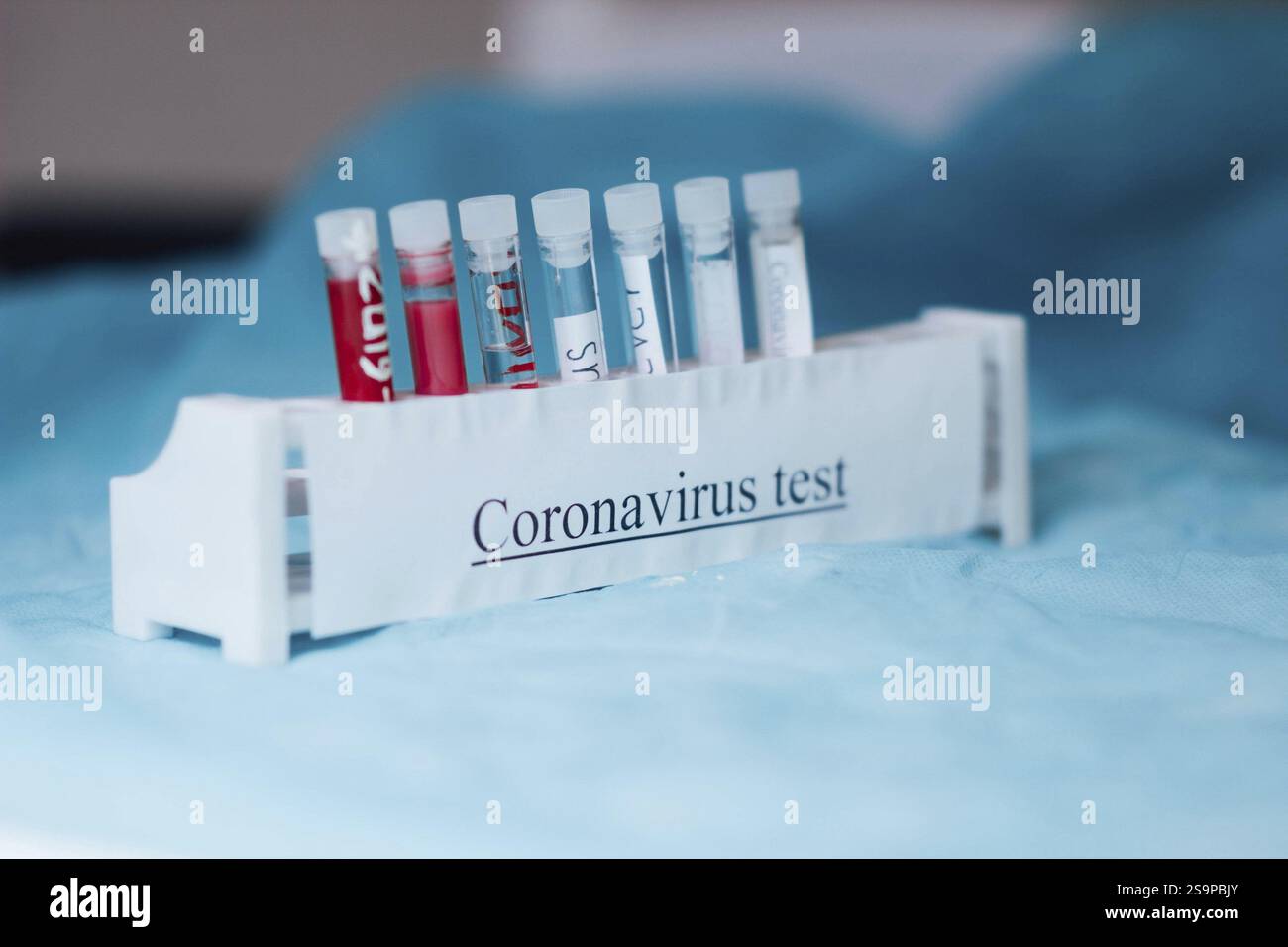 Test tubes labeled for coronavirus testing placed in a holder on a blue ...