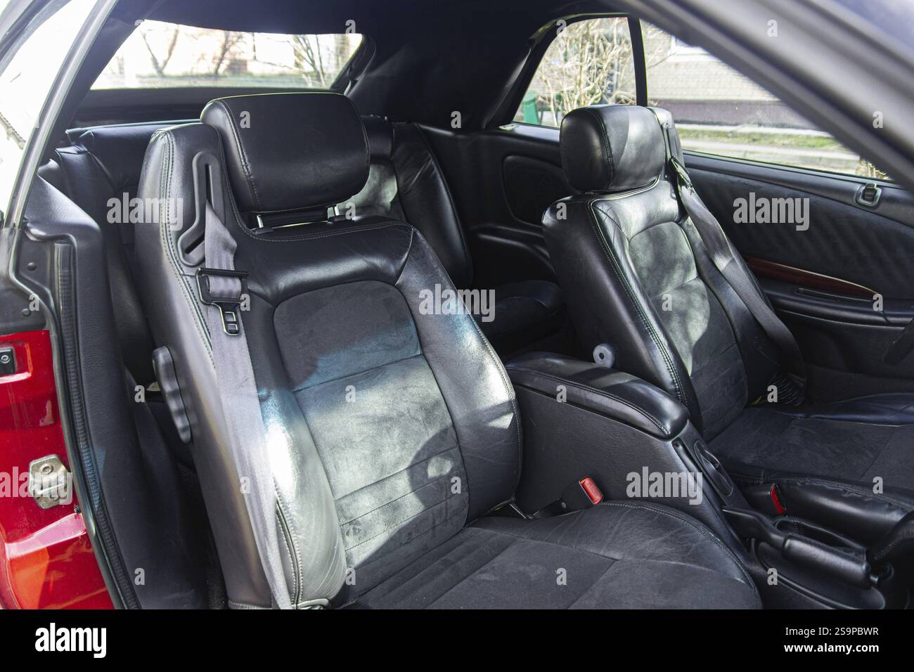 Spacious car interior with black leather seats and headrest, bathed in ...