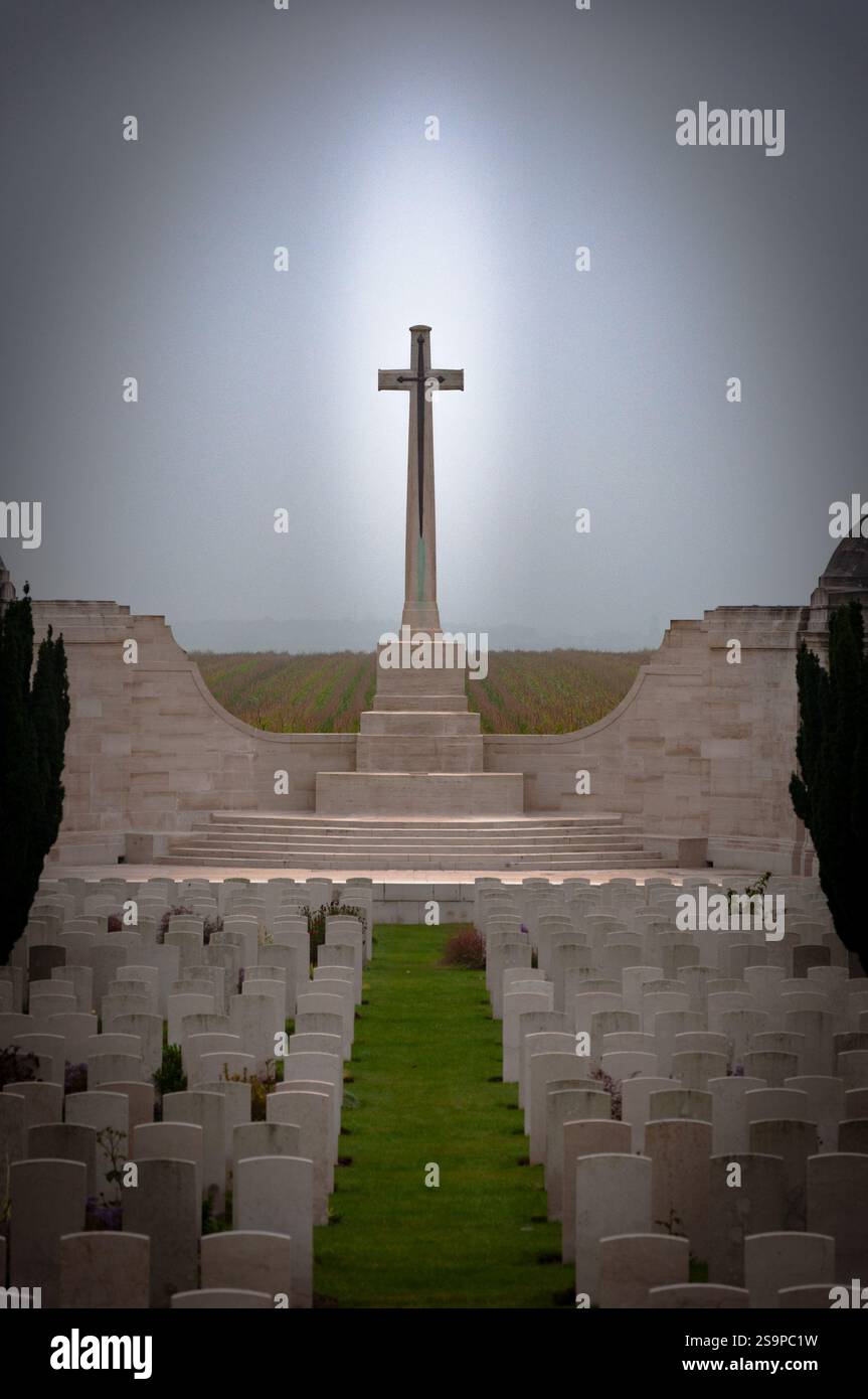 A sombre scene at a war cemetery. Numerous simple white headstones line ...