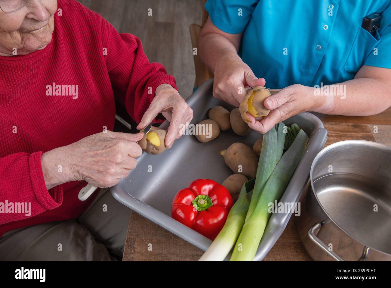 Preparing a meal, peeling potatoes. Patients in geriatric care home ...
