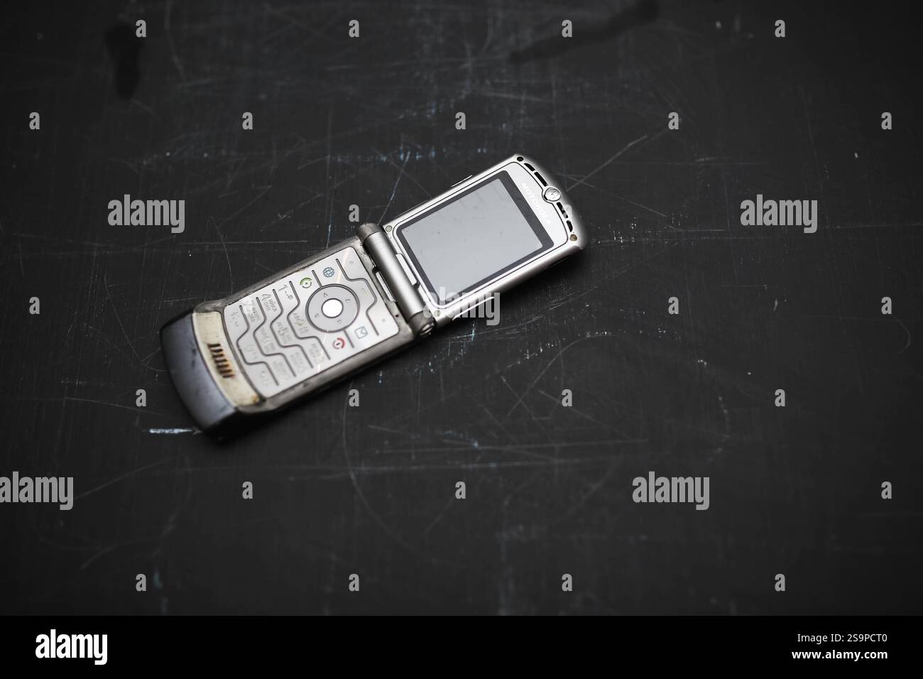 An open Motorola RAZR phone laying on a scratched black surface Stock ...