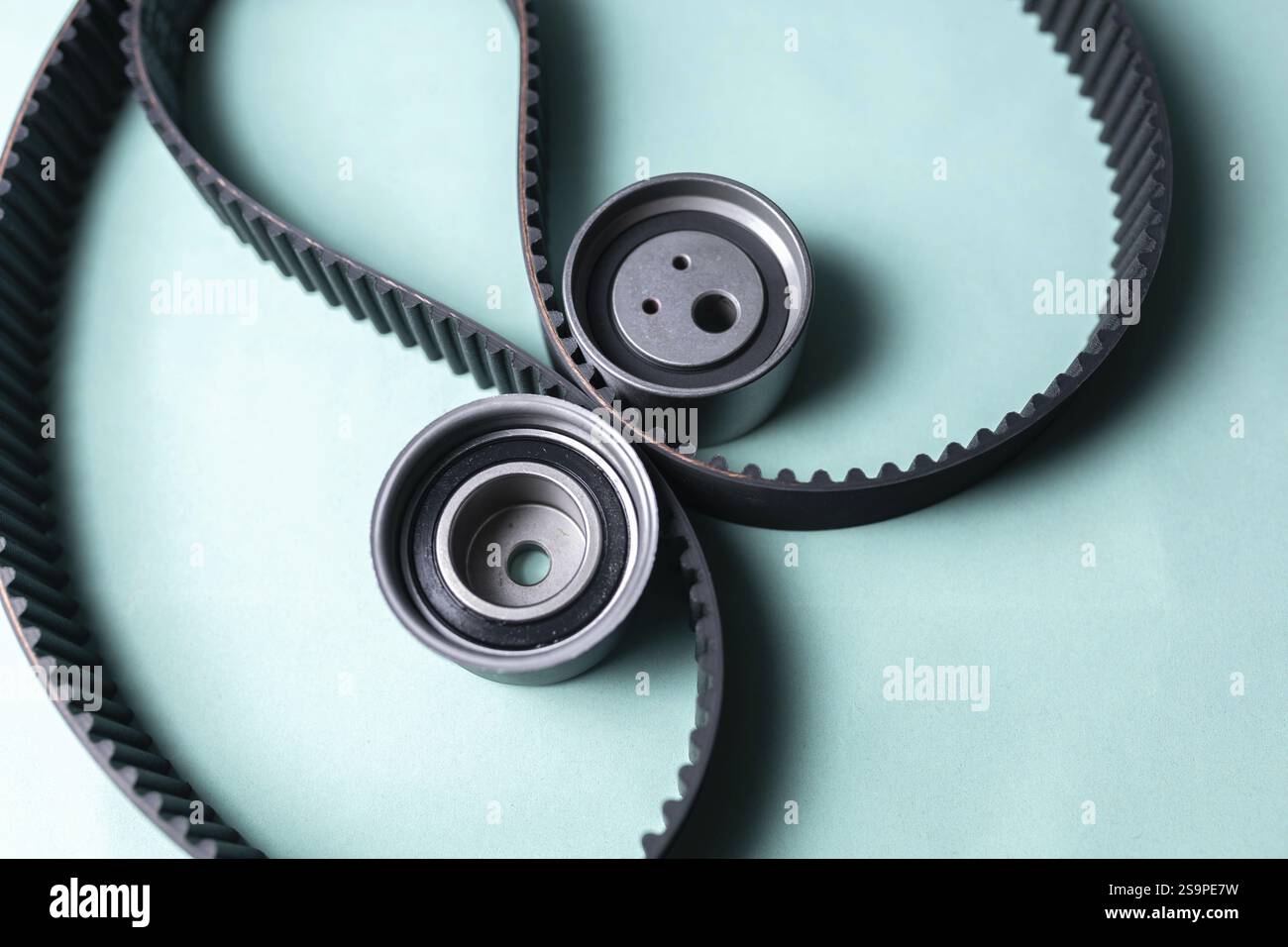 Timing belt and gears arranged on a mint green surface Stock Photo - Alamy