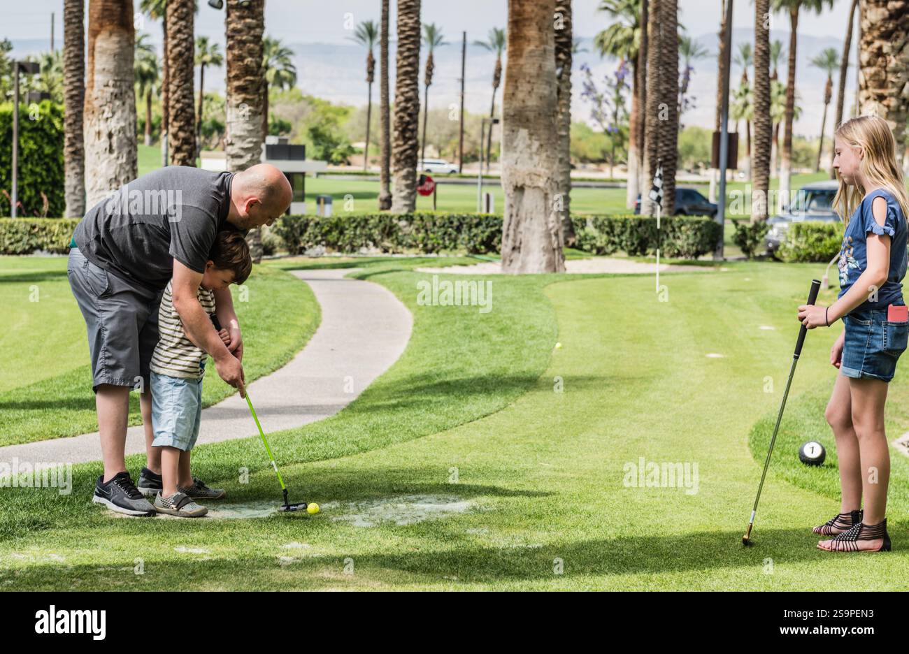 Palm Desert, CA USA - May 6, 2018: Family putting on the mini golf ...