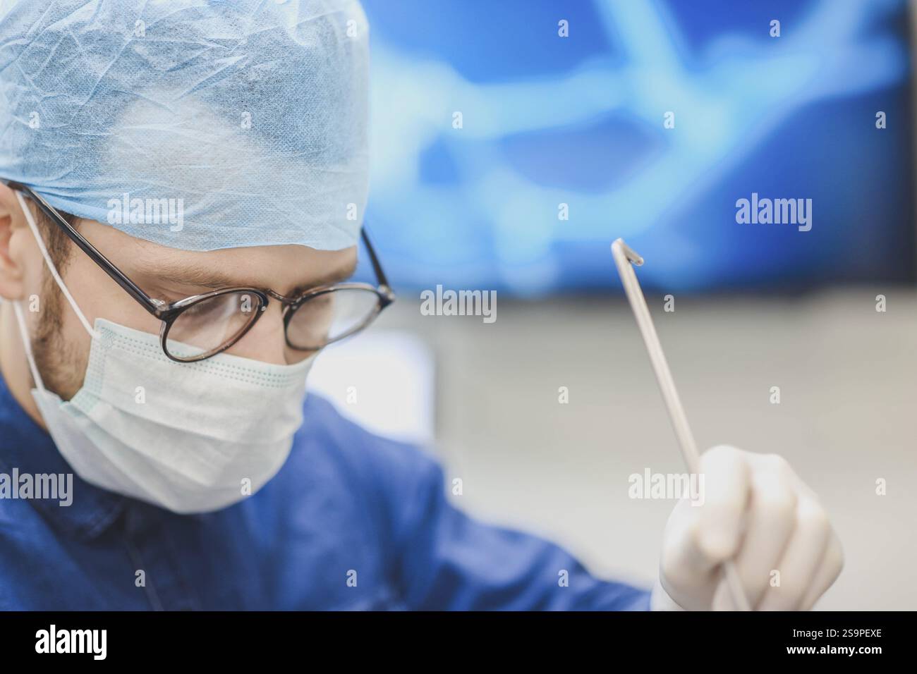 Doctor using surgical instrument, focused on task in a medical room ...