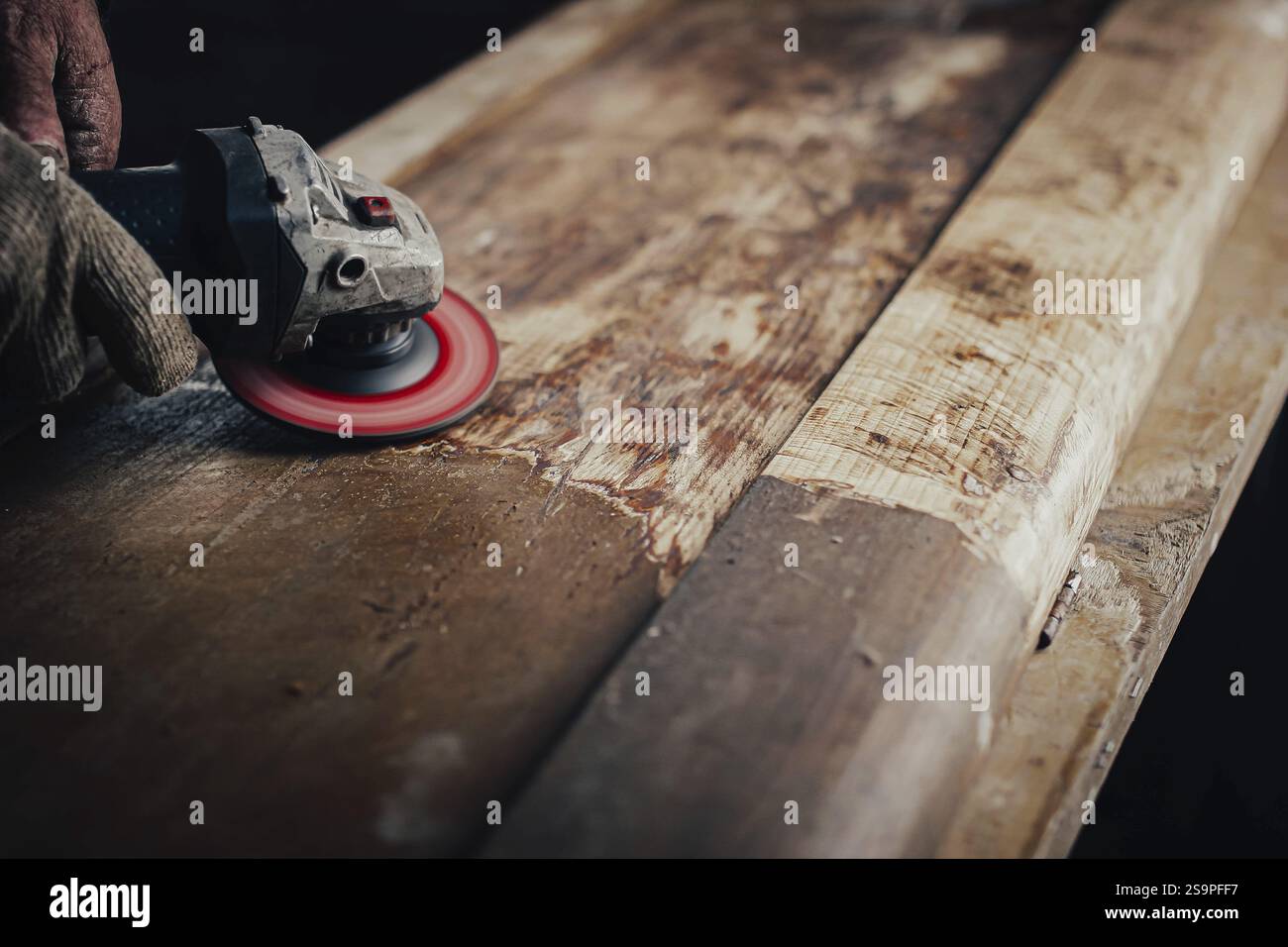 A grinding tool is applied to a wooden surface, highlighting texture ...