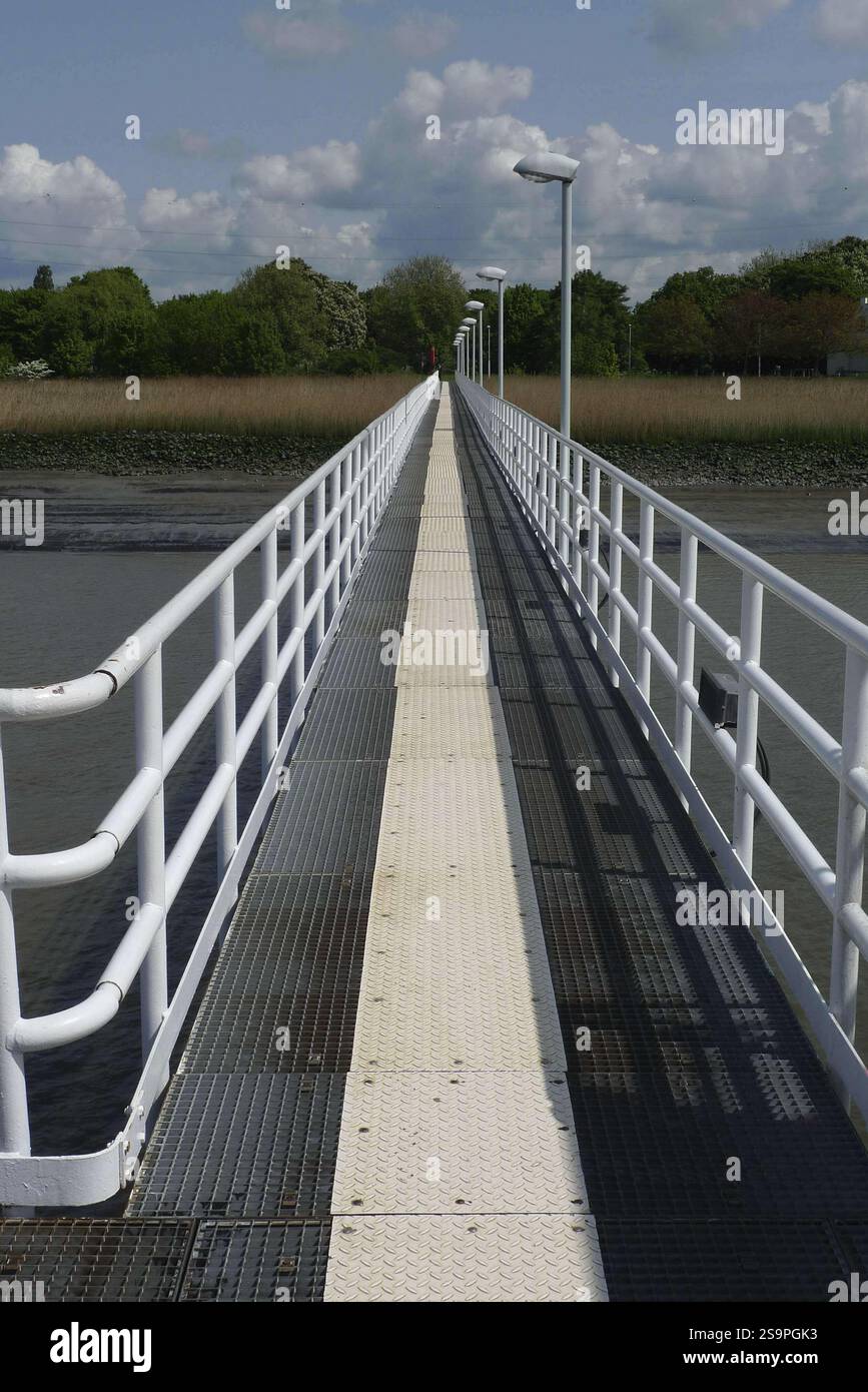 A long jetty stretches straight across the water, flanked by white ...