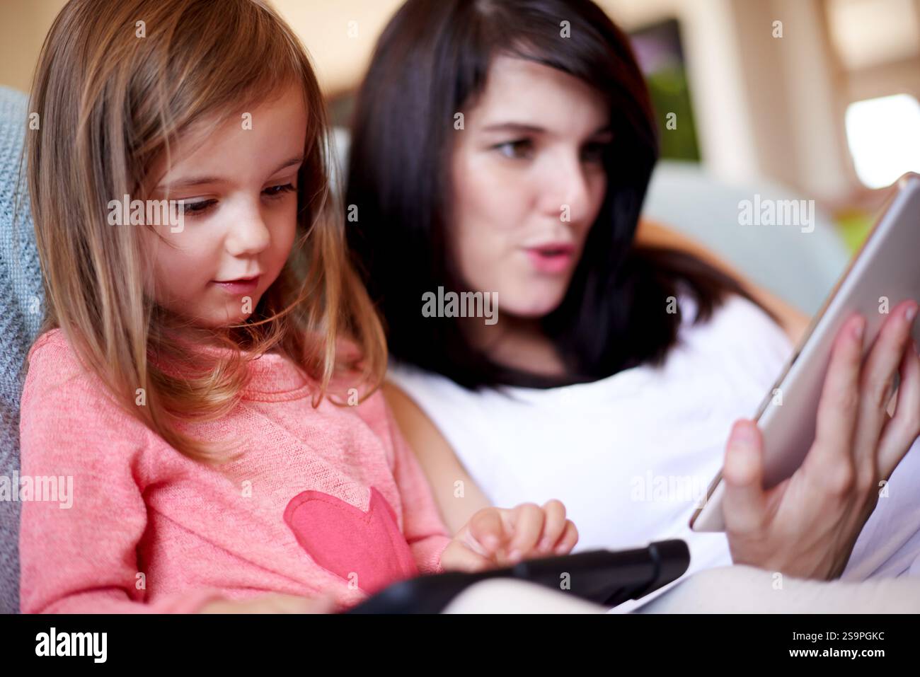 Tablet, relax and mother with kid on sofa in living room for ...