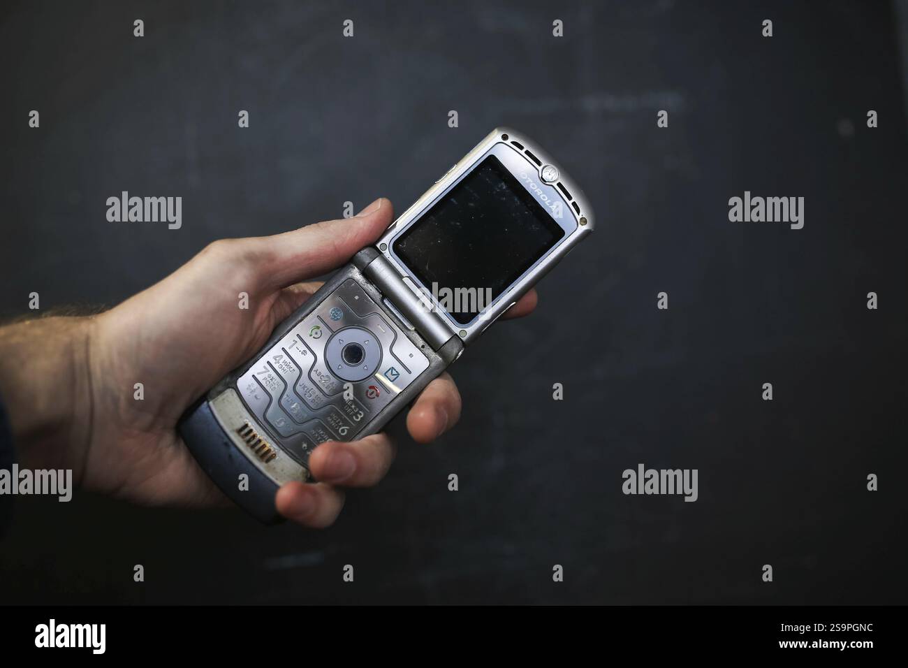 A hand holding an open Motorola RAZR flip phone Stock Photo - Alamy
