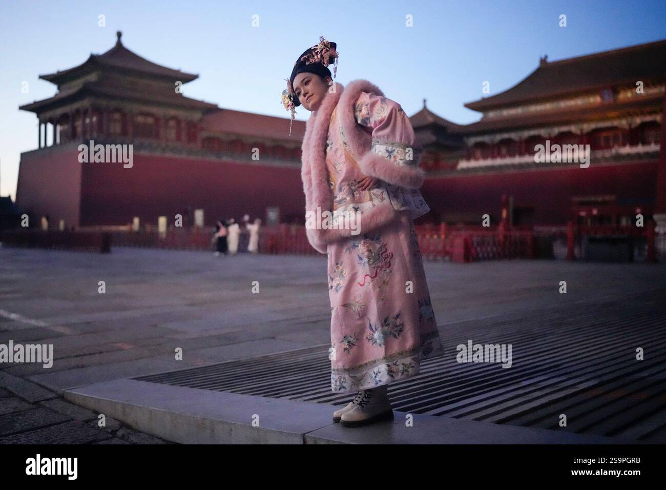 A woman in a traditional costume poses to have her picture taken ...
