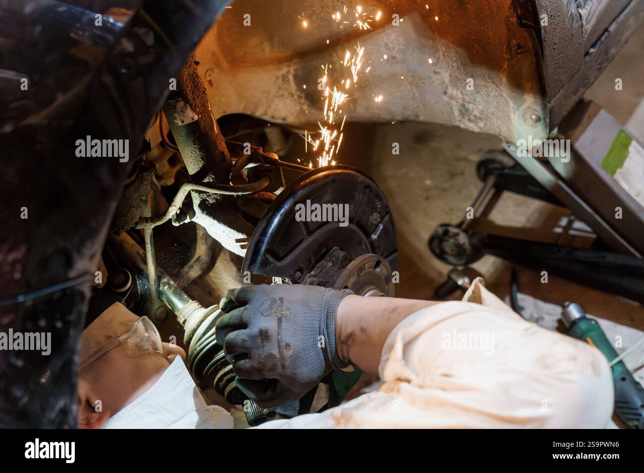 Mechanic Working on Car Brake Assembly with Sparks Flying Stock Photo ...