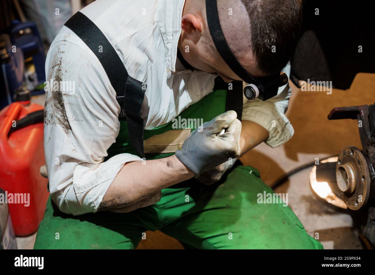 Mechanic Focusing on Precision Work in a Dimly Lit Garage Stock Photo ...
