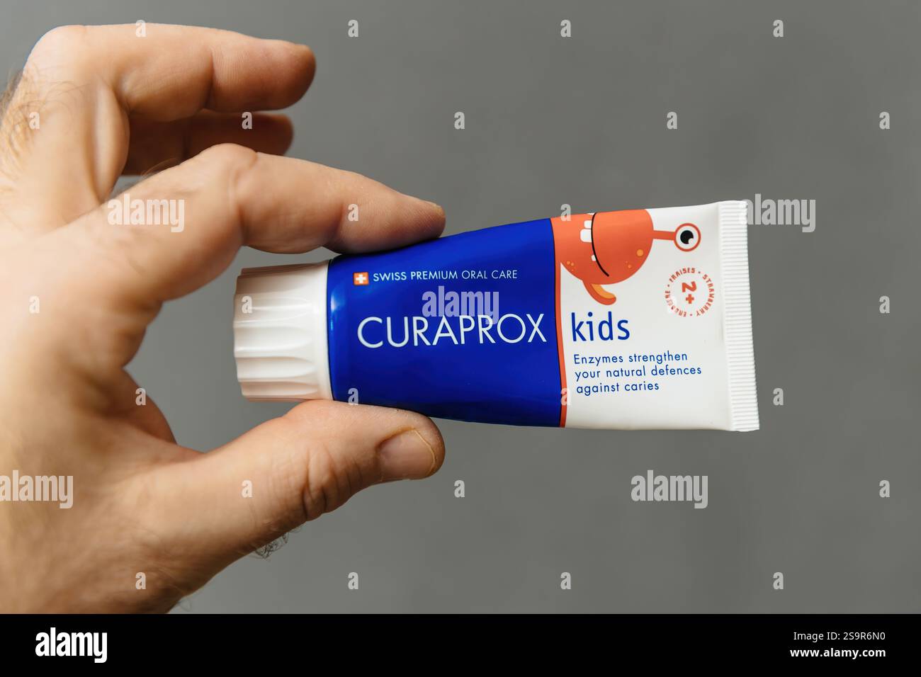 Paris, France - Jan 18, 2025: A hand holding a Curaprox Kids toothpaste ...