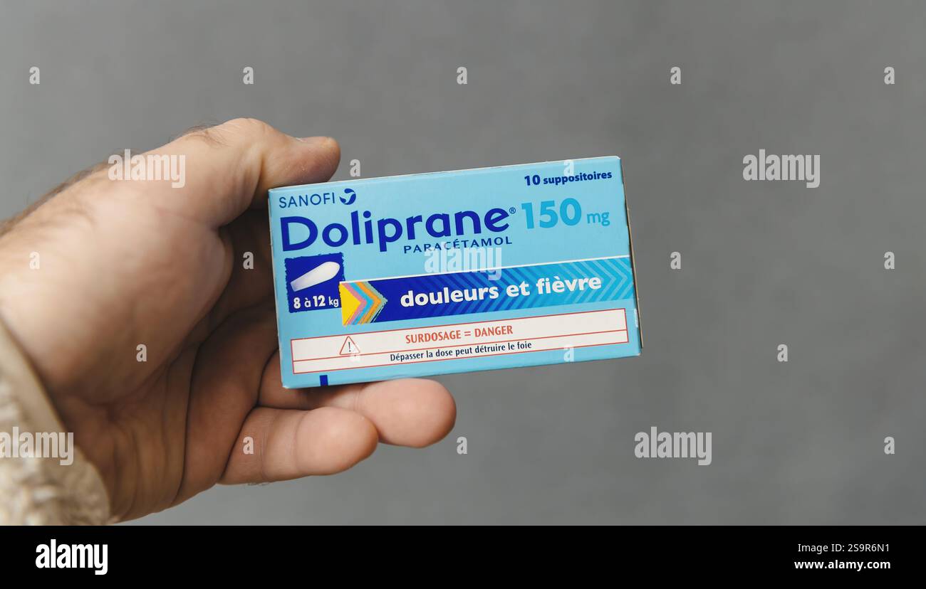 Paris, France - Jan 18, 2025: A hand holding a box of Doliprane 150mg ...