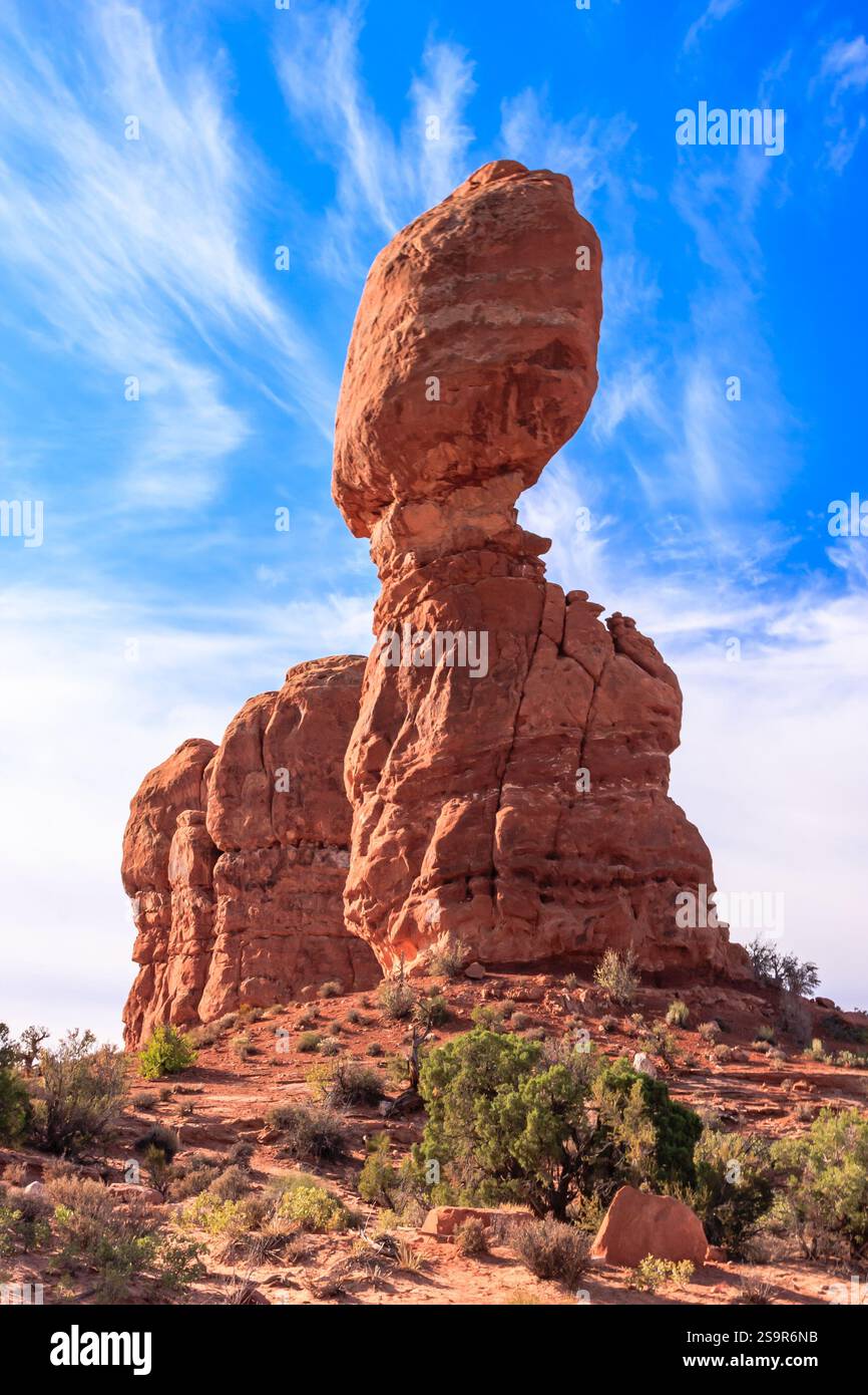 A large rock formation with a pointy top. The sky is blue and there are ...
