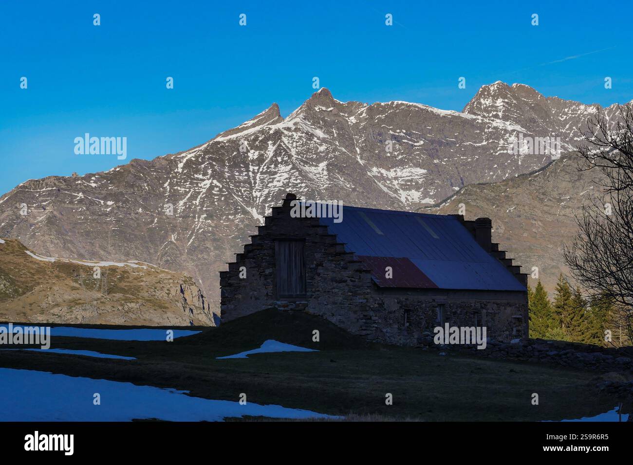 Majestic mountain backdrop highlights an old stone structure in a ...