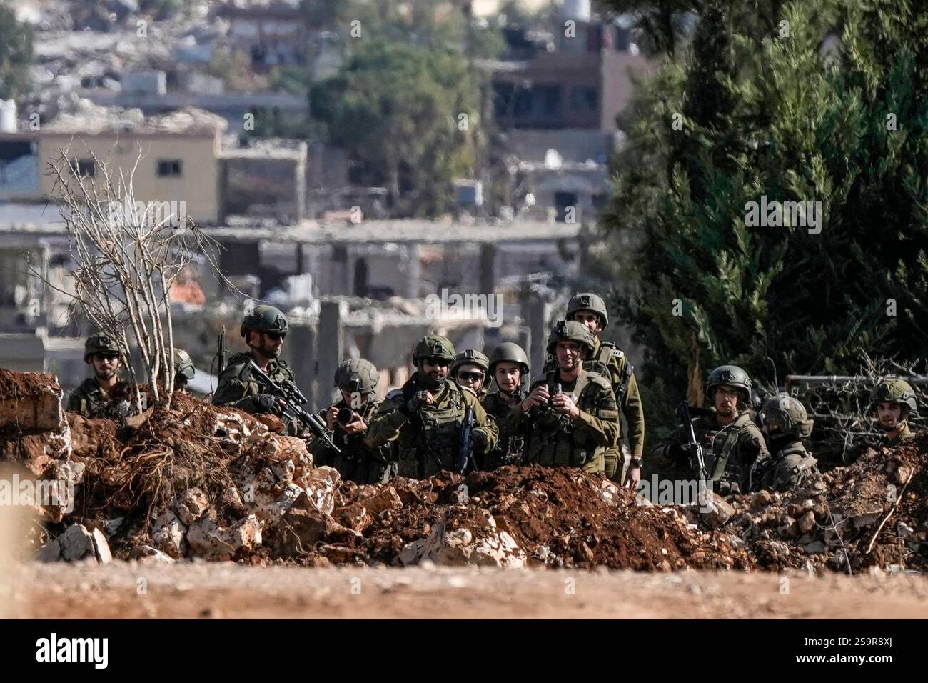 Israeli soldiers take a position to block a road in the southern ...